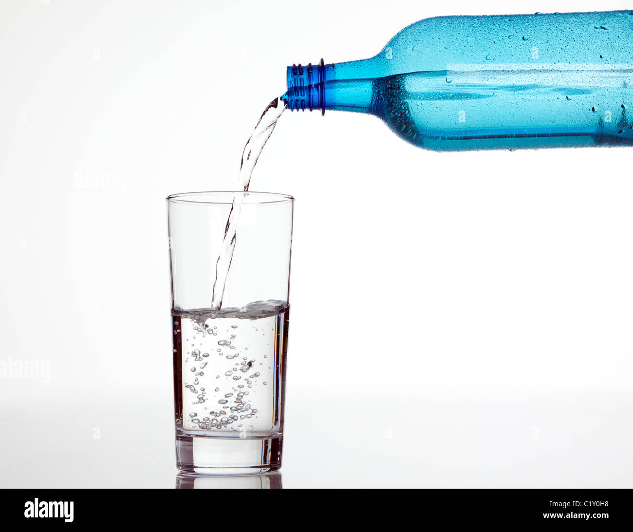 filling mineral water from a blue bottle into glass Stock Photo - Alamy