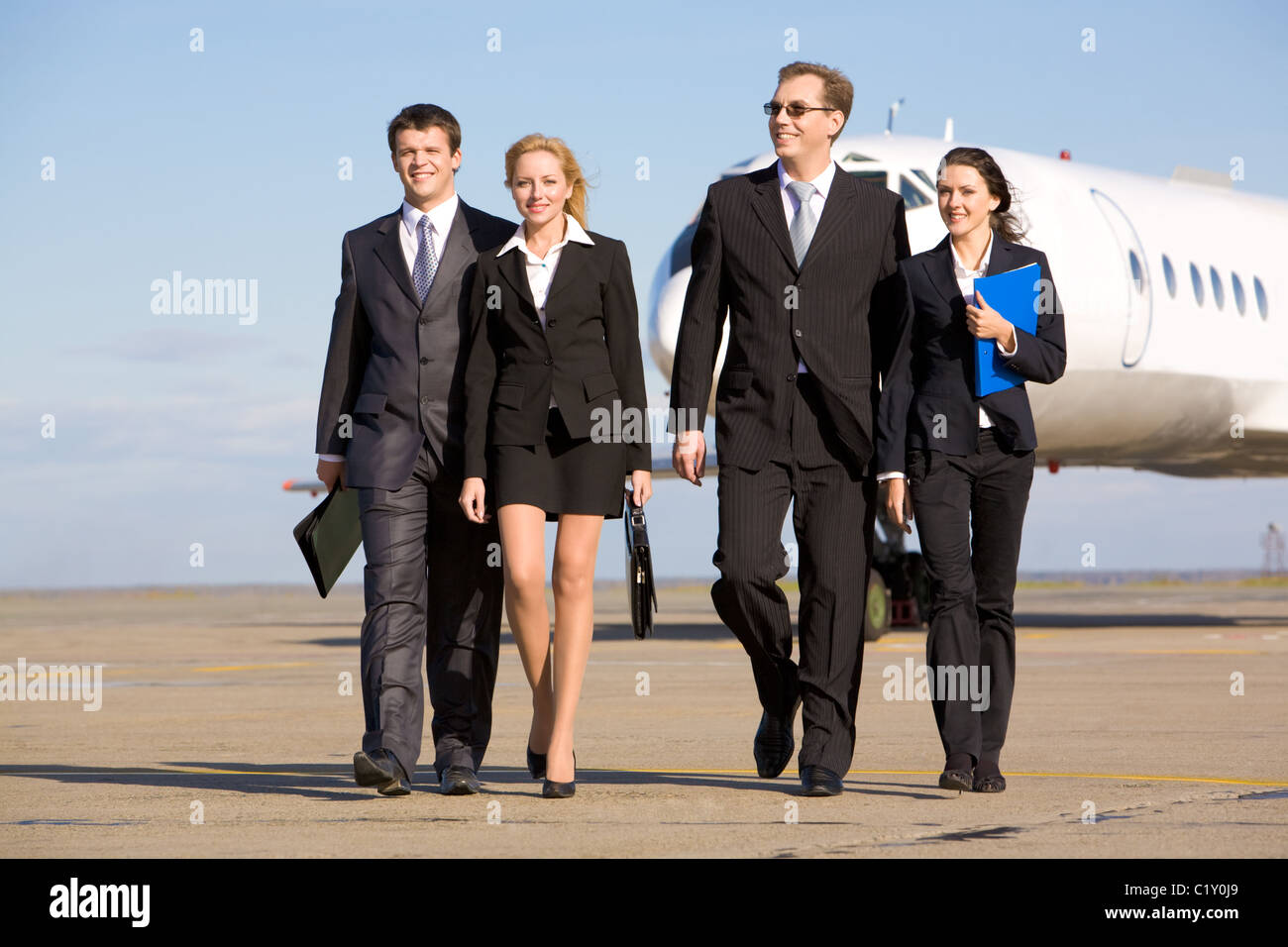 Group of successful people walking on the background of the airplane ...