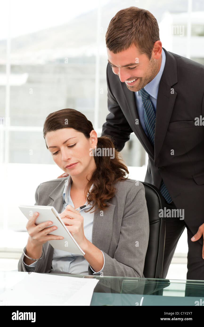 Concentrated woman taking notes whiletalking to her manager Stock Photo ...