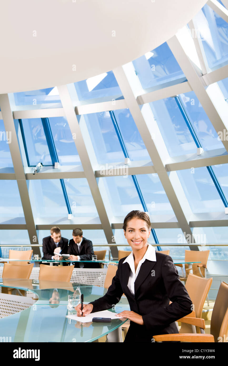 Confident woman sitting in the conference room and smiling Stock Photo ...