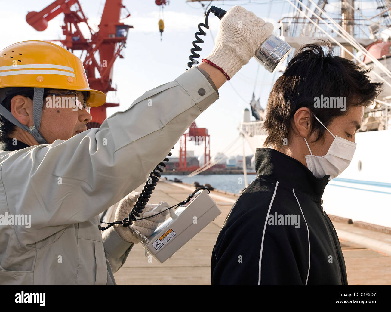 A member of the so-called Fukushima 50 is given a radiation check prior ...