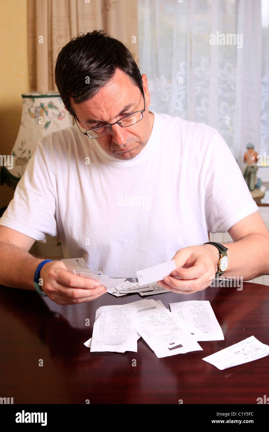 Adult Man checking his receipts from stores and how much things are ...