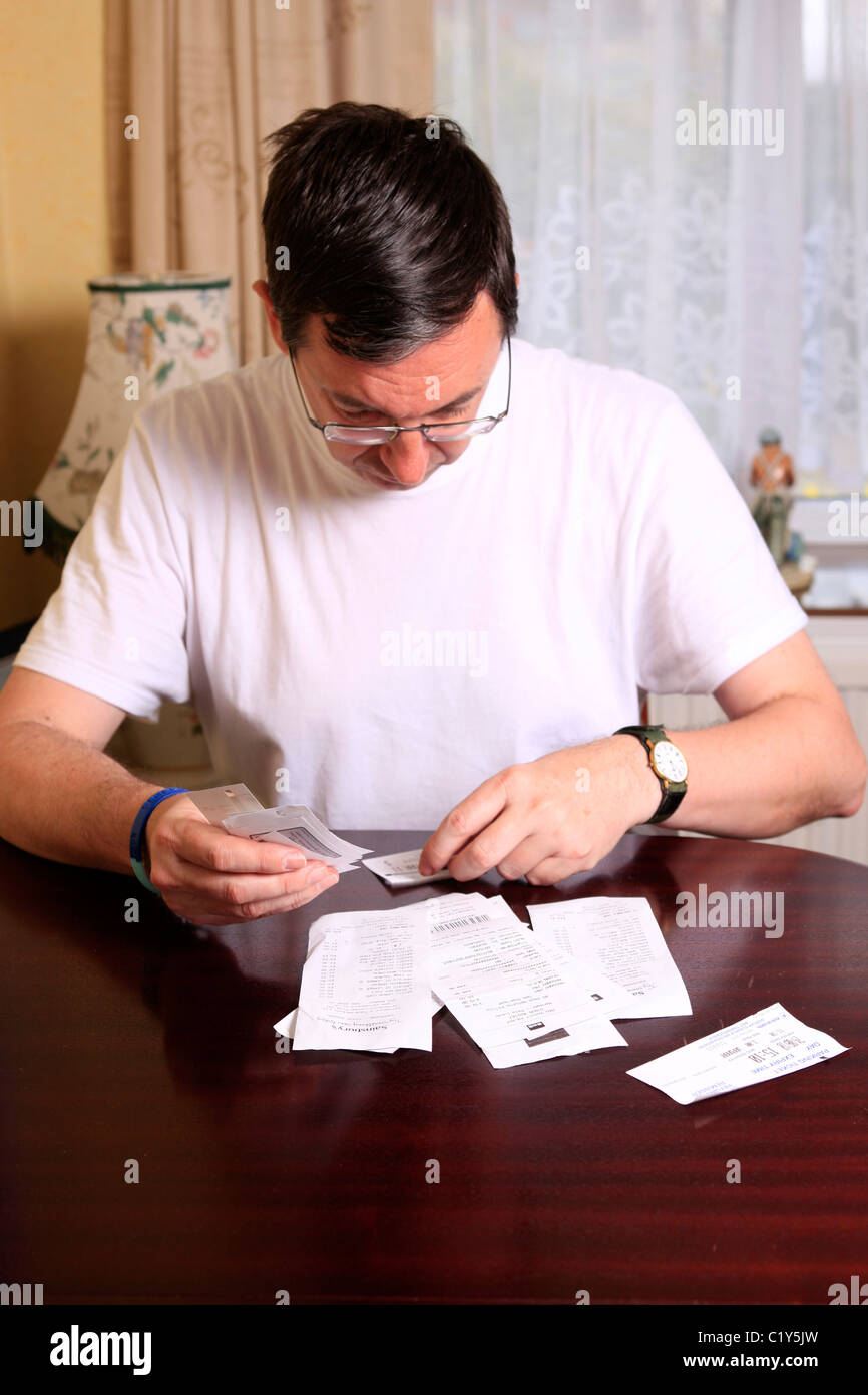 Adult Man checking his receipts from stores and how much things are ...