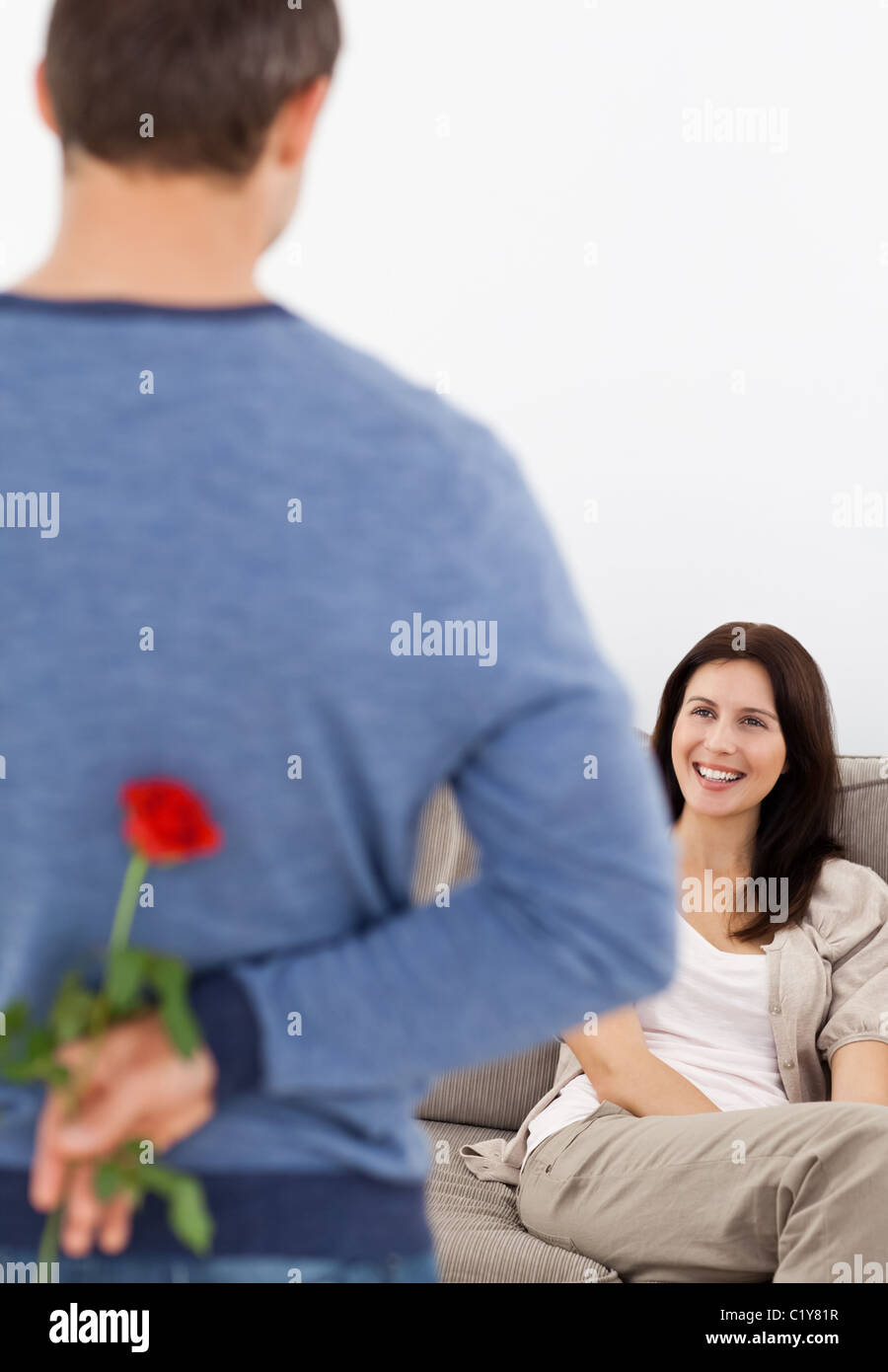 Enamored man hiding a flower behind his back for his girlfriend Stock ...