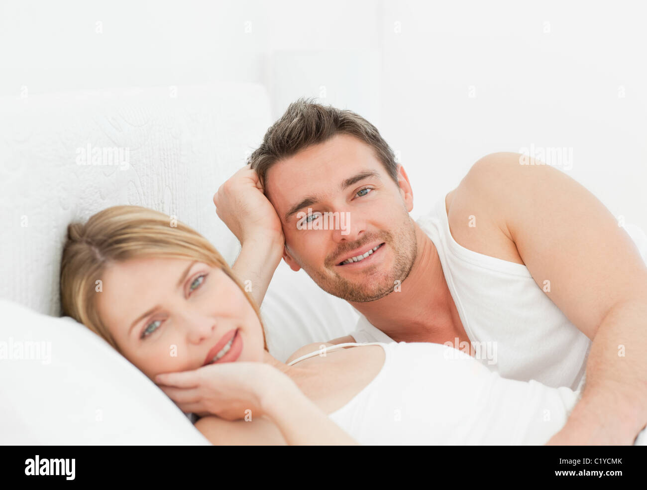Cute couple lying down together in their bed Stock Photo - Alamy
