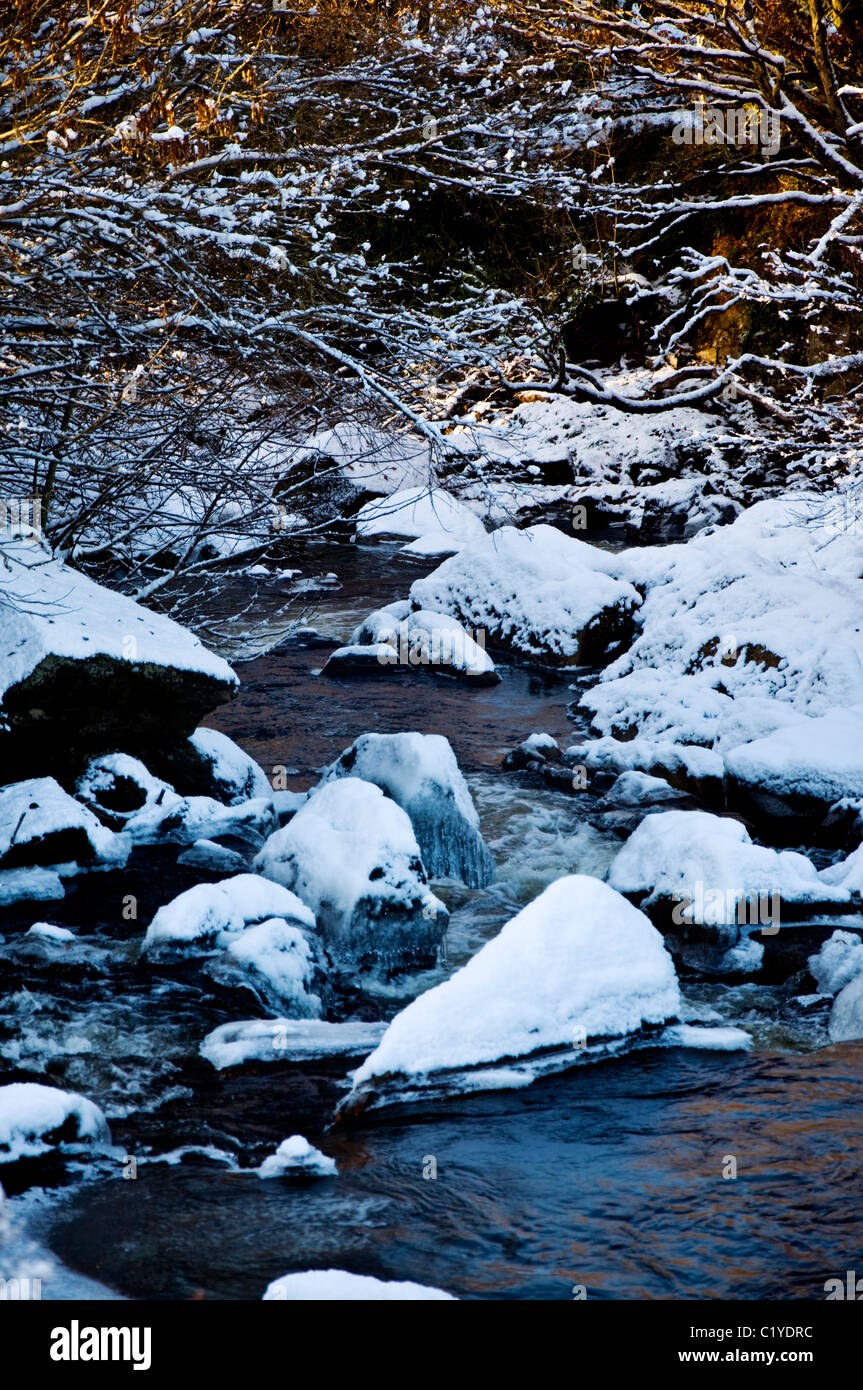 Stream flowing in winter snow scene Stock Photo - Alamy