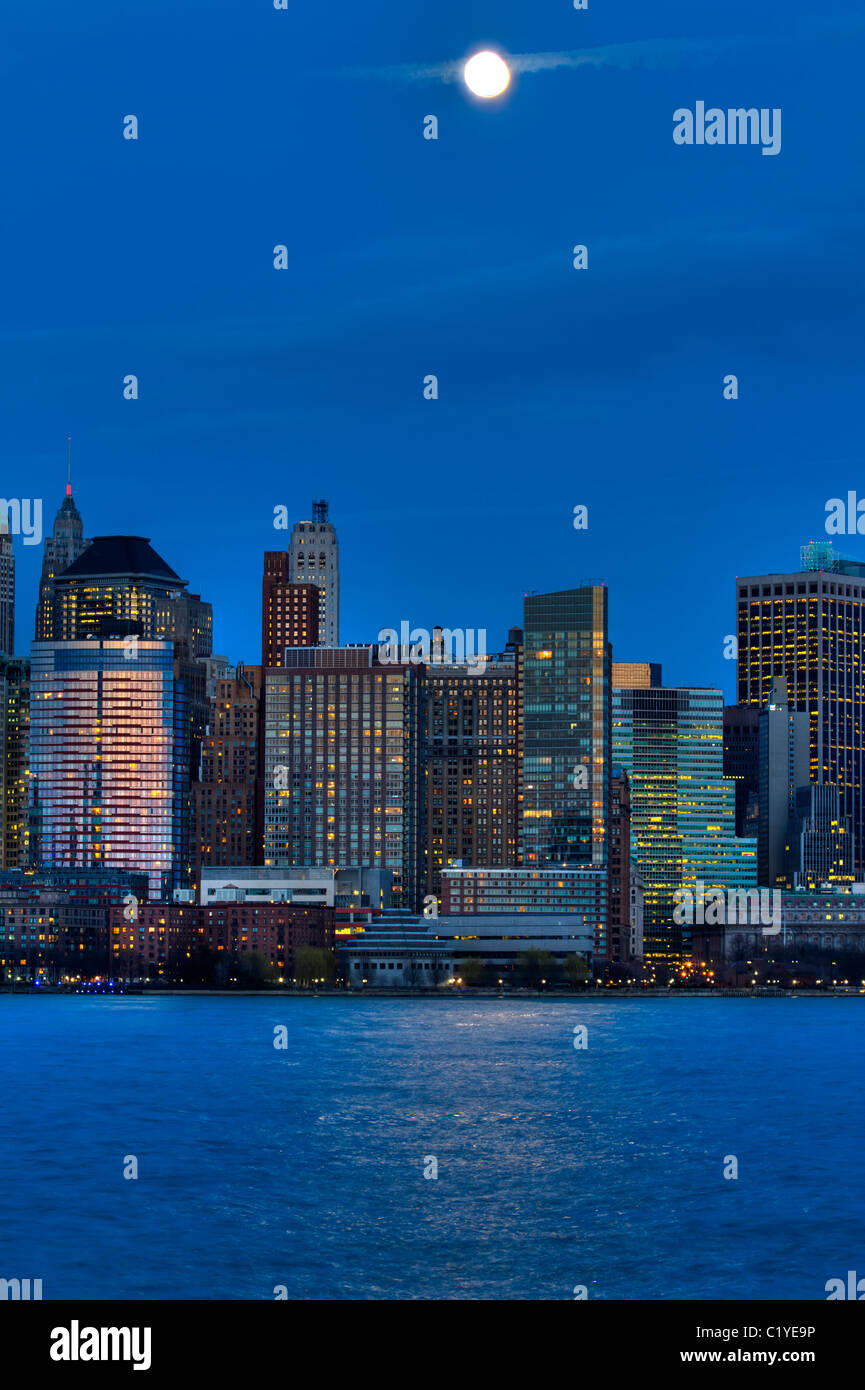 Full moon over lower Manhattan at night seen from across the Hudson ...