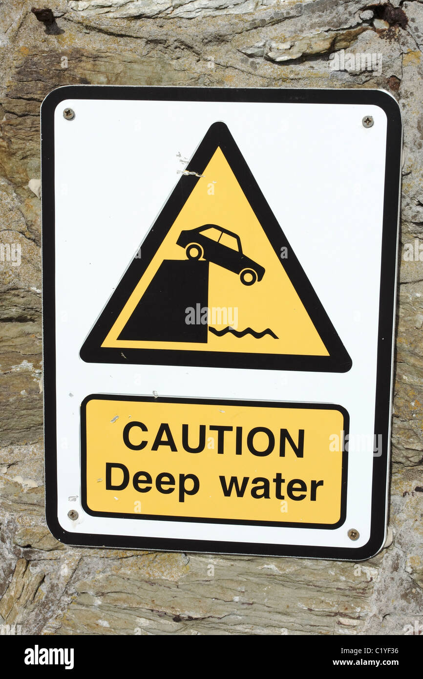 A "CAUTION Deep Water" sign on a quayside wall in Holyhead harbour ...