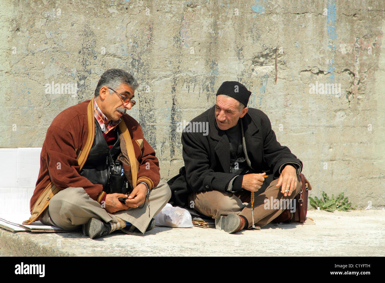 Turkish men chatting sitting at a wall Stock Photo - Alamy