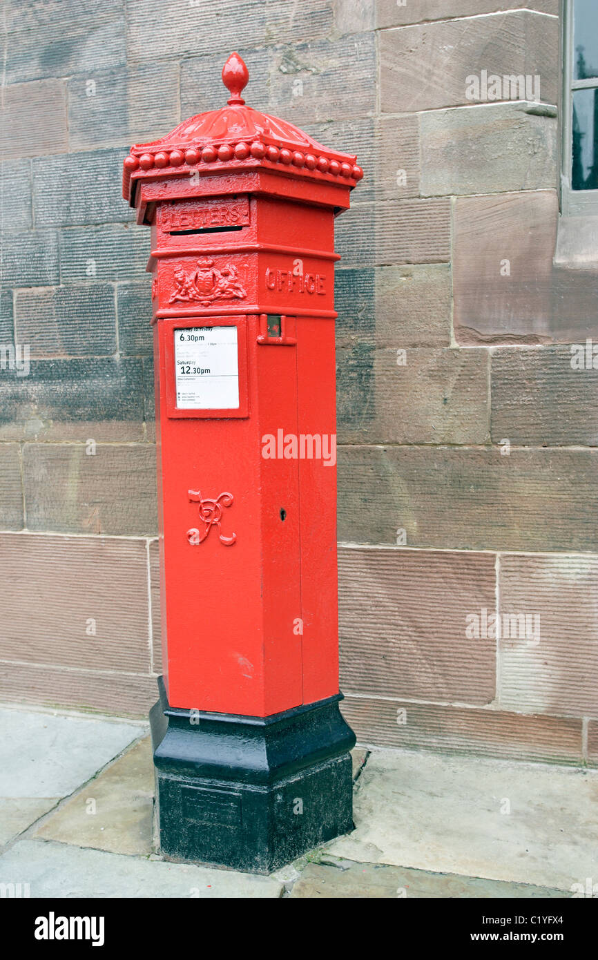 A red Victorian postbox outside the town hall in the historic city of ...
