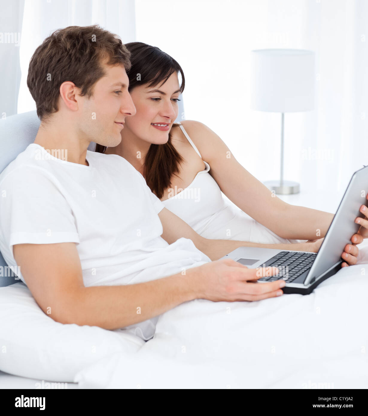 Young couple watching videos on their computer at home Stock Photo - Alamy