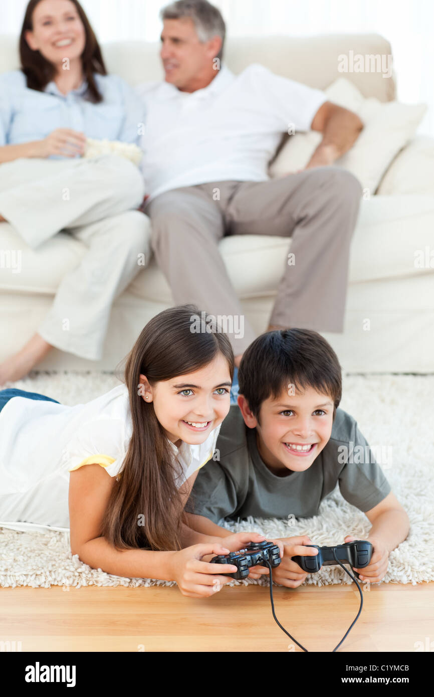 Children playing videogames while parents are talking Stock Photo - Alamy
