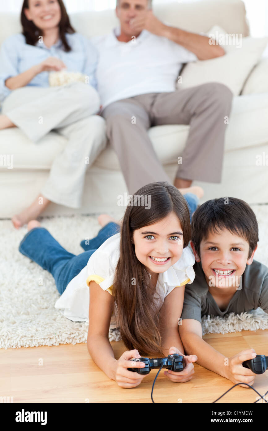 Children playing videogames while parents are talking Stock Photo - Alamy