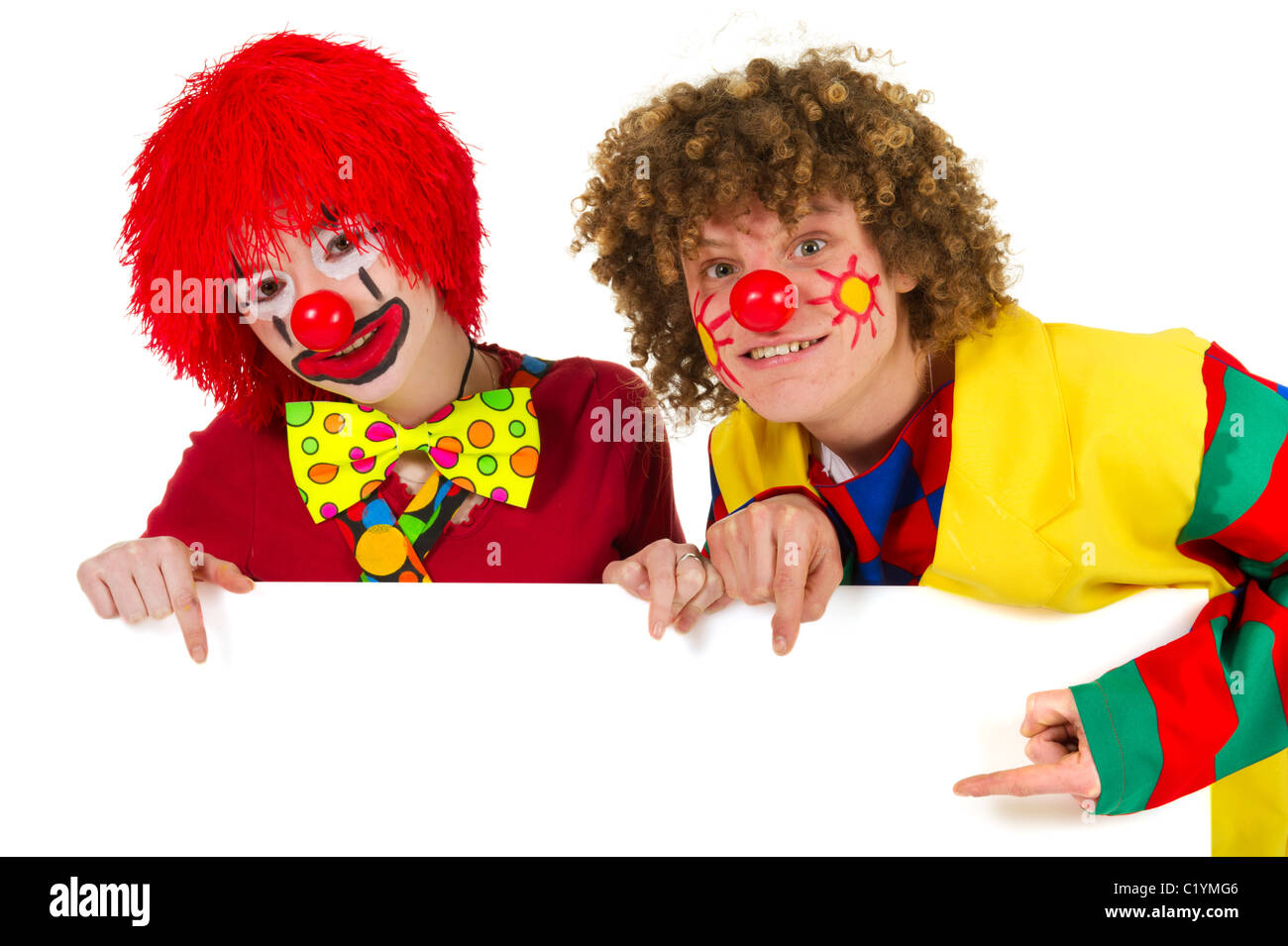 Two funny clowns are pointing to an empty white board for text Stock ...