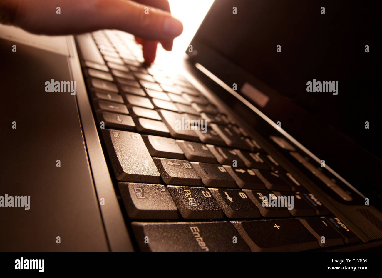 Laptop background, with a hand hitting a key in the back Stock Photo ...