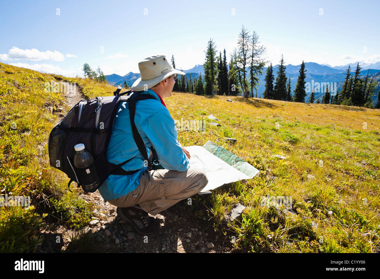 A hiker on the Pacific Crest Trail checking his map. Washington ...