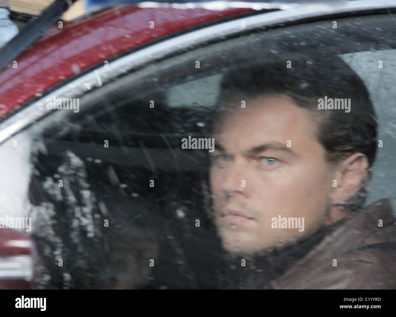 Leonardo DiCaprio driving a car in the rain while filming a scene for ...