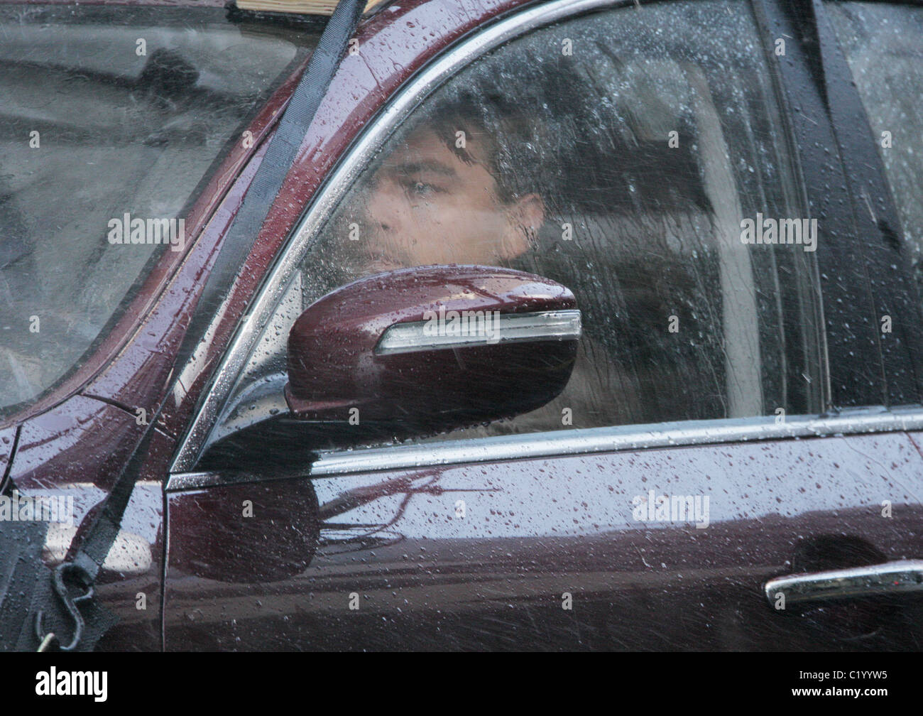 Leonardo DiCaprio driving a car in the rain while filming a scene for ...