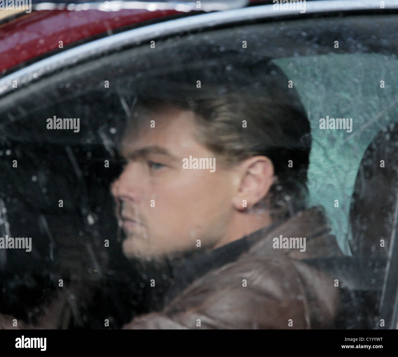 Leonardo DiCaprio driving a car in the rain while filming a scene for ...