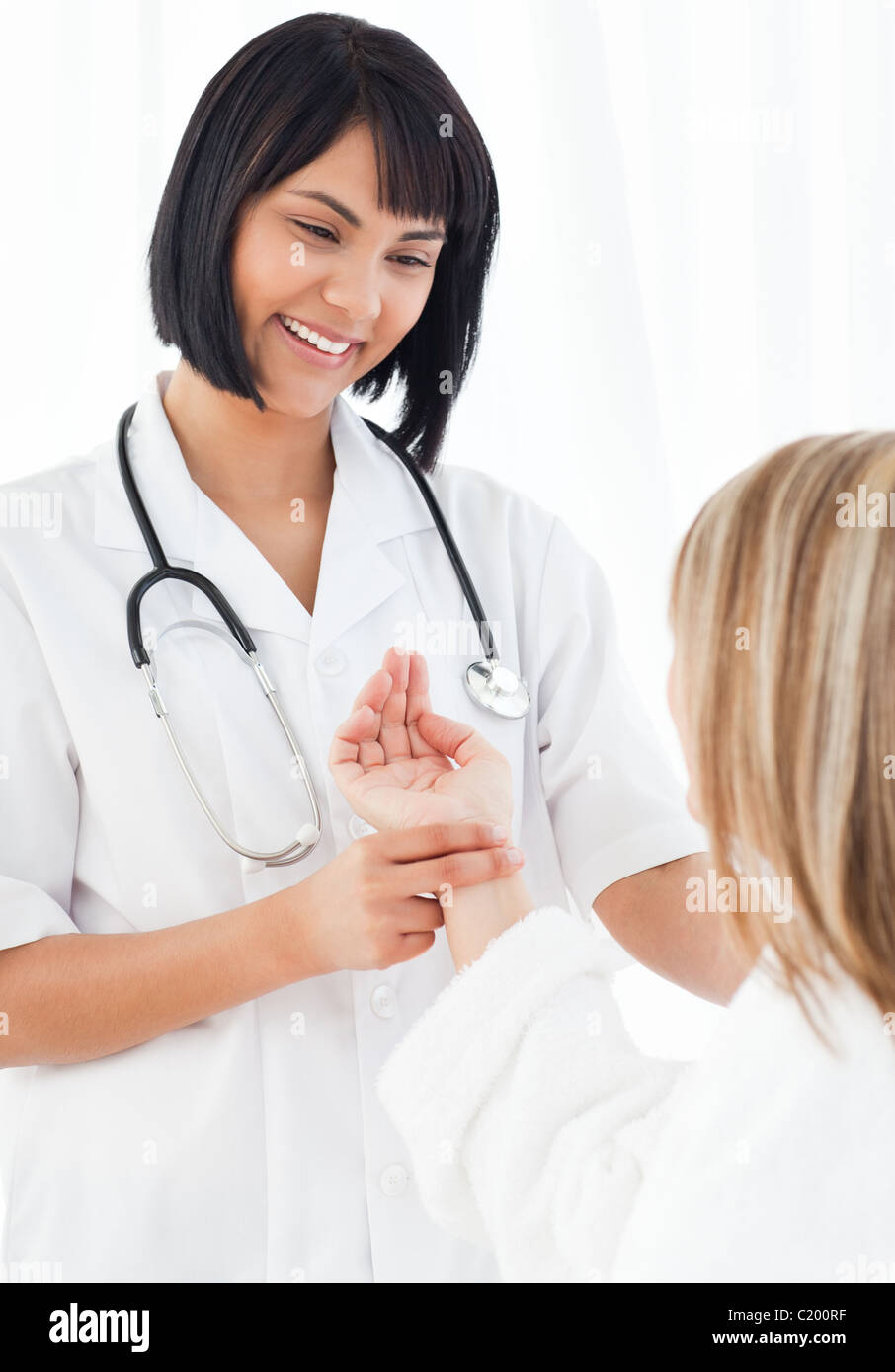 Nurse taking the pulse of a woman Stock Photo - Alamy