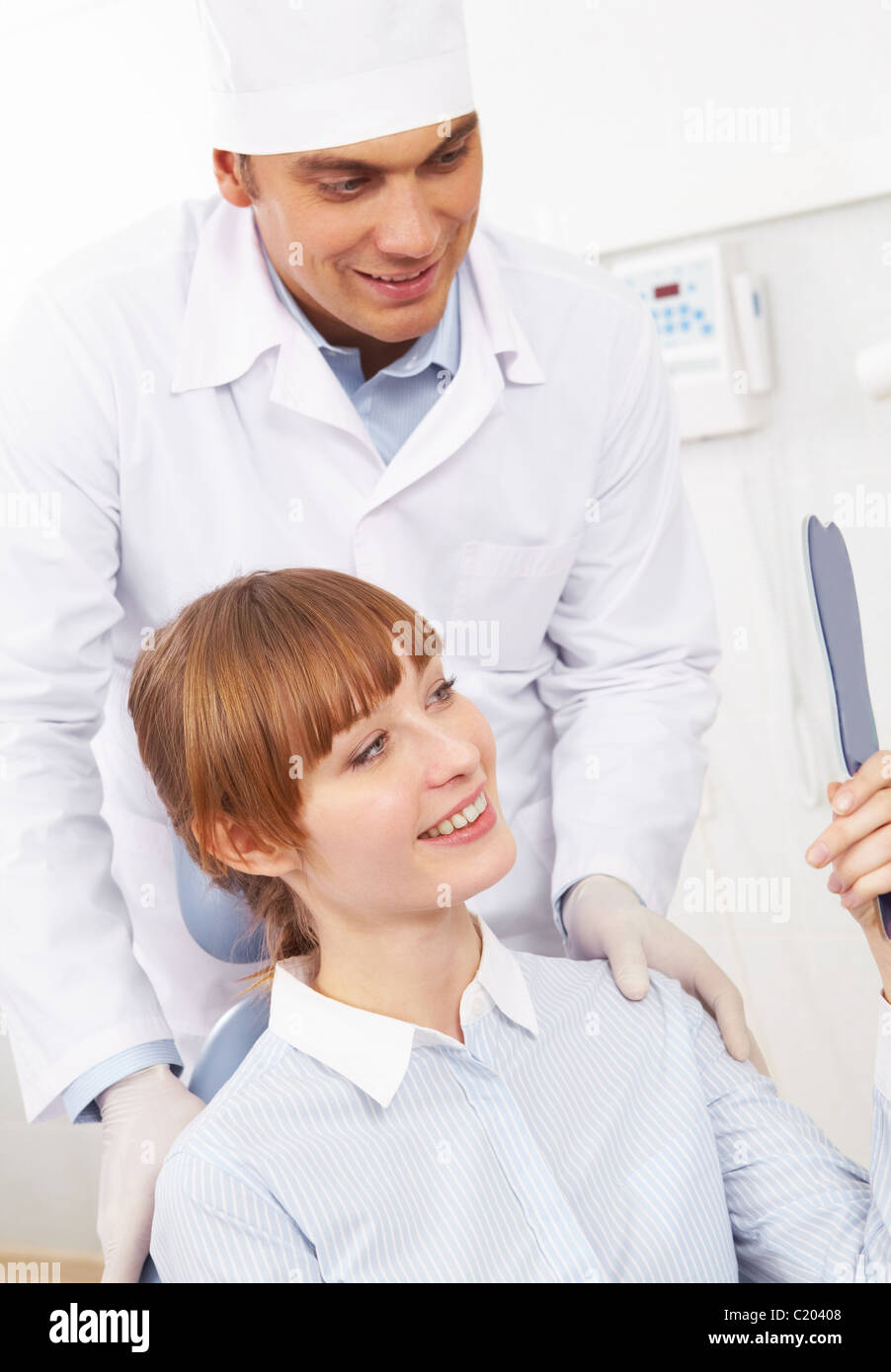 Photo of patient holding mirror with doctor behind Stock Photo - Alamy