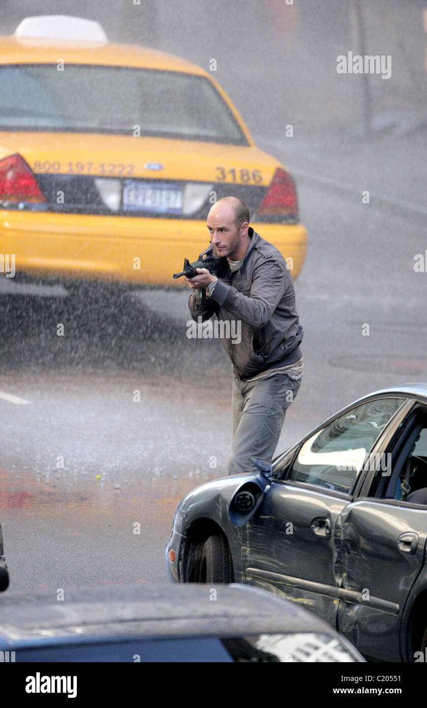 Actors stage a gun fight in the rain filming a scene for 'Inception ...