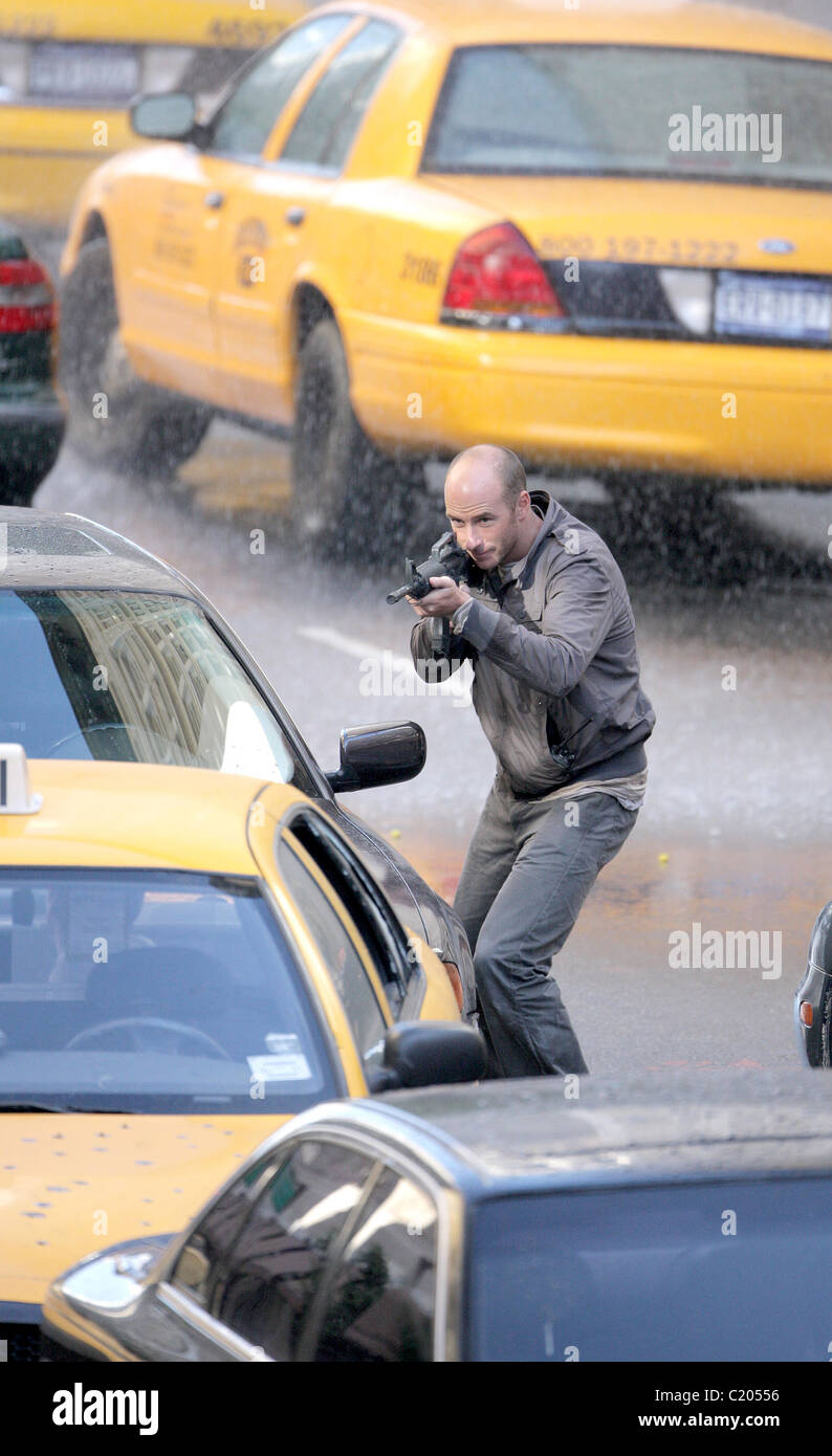 Actors stage a gun fight in the rain filming a scene for 'Inception ...