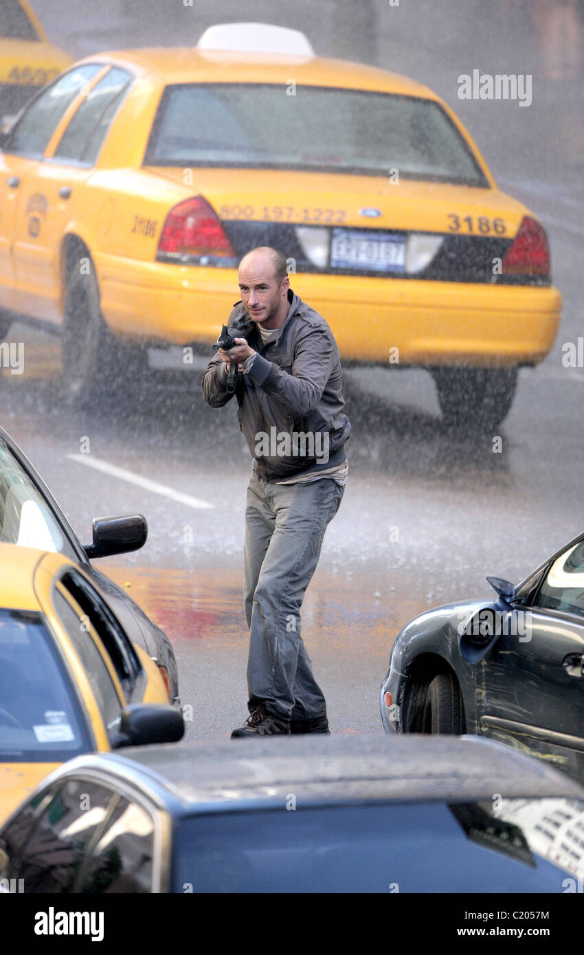 Actors stage a gun fight in the rain filming a scene for 'Inception ...