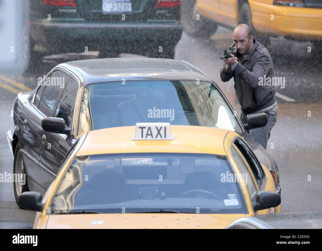 Actors stage a gun fight in the rain filming a scene for 'Inception ...
