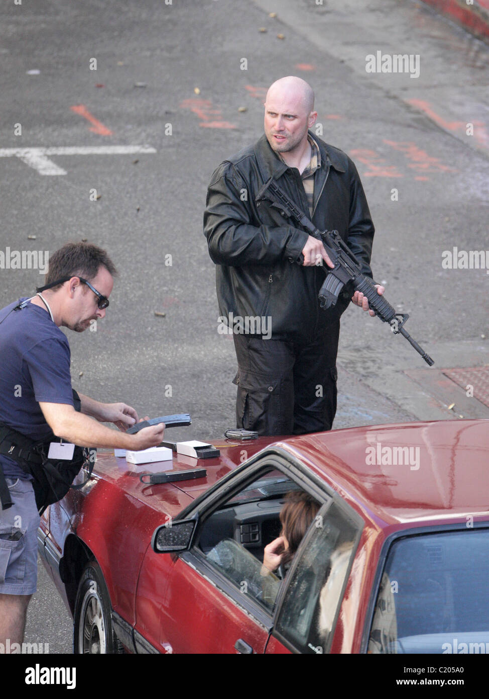 Actors stage a gun fight in the rain filming a scene for 'Inception ...