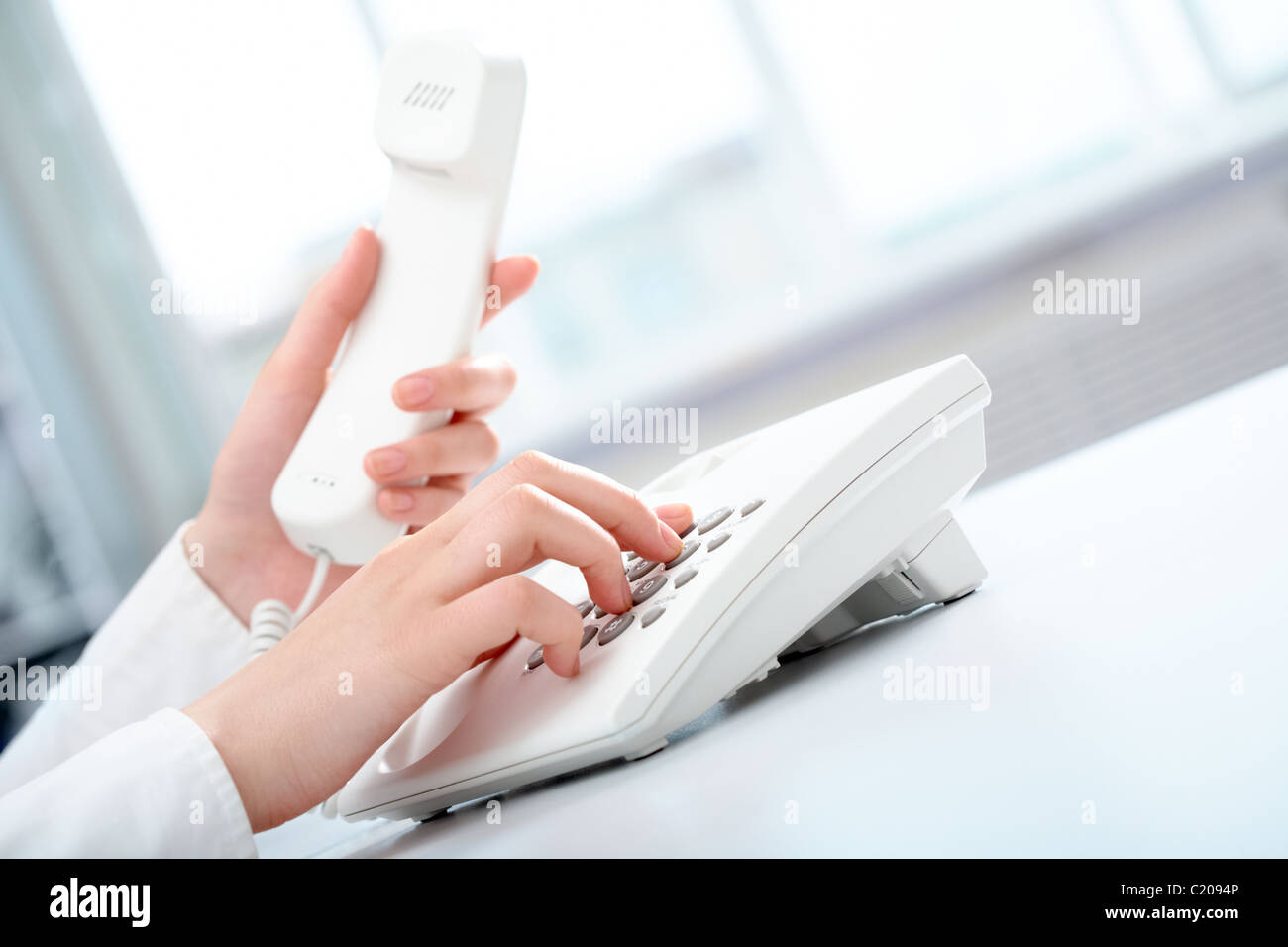Photo Of Female Hands Dialing On White Telephone Stock Photo Alamy