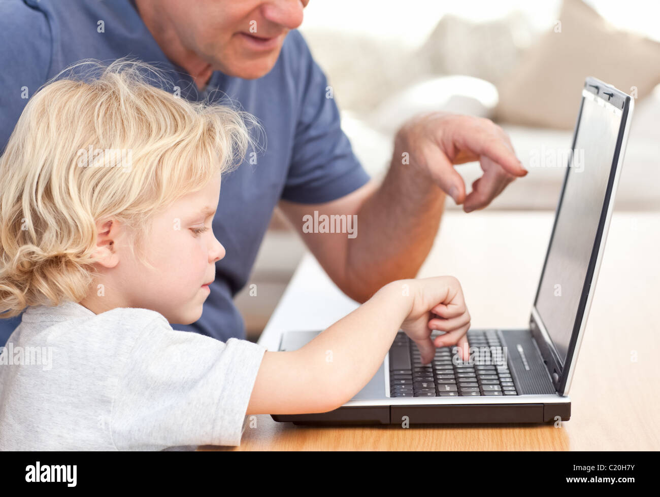 Lovely boy and his grandfather looking at their laptop Stock Photo - Alamy