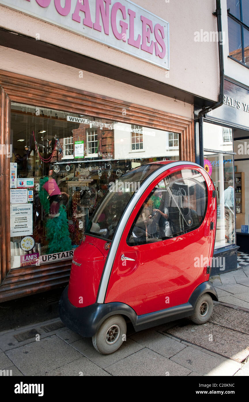 Shoprider mobility scooter parked on a pavement outside a shop in a ...