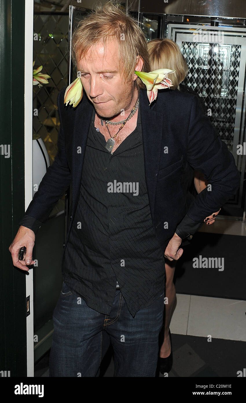 Rhys Ifans leaving the Ivy Club with flowers sticking out of his ears ...