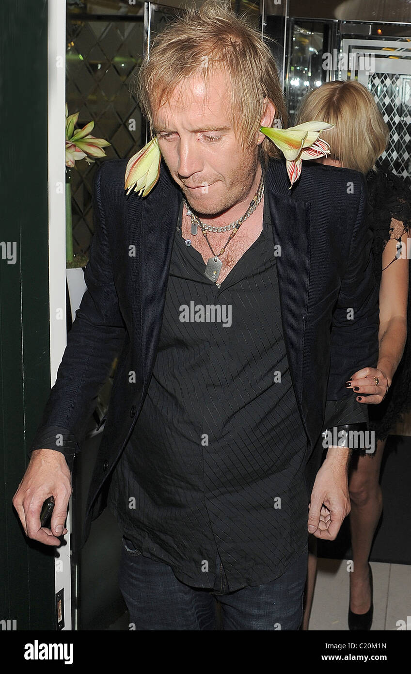 Rhys Ifans leaving the Ivy Club with flowers sticking out of his ears ...