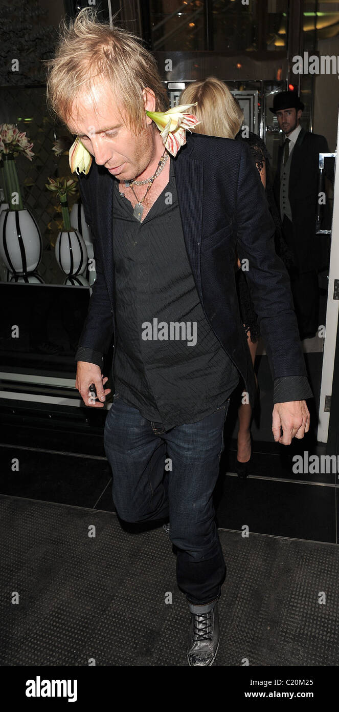 Rhys Ifans leaving the Ivy Club with flowers sticking out of his ears ...
