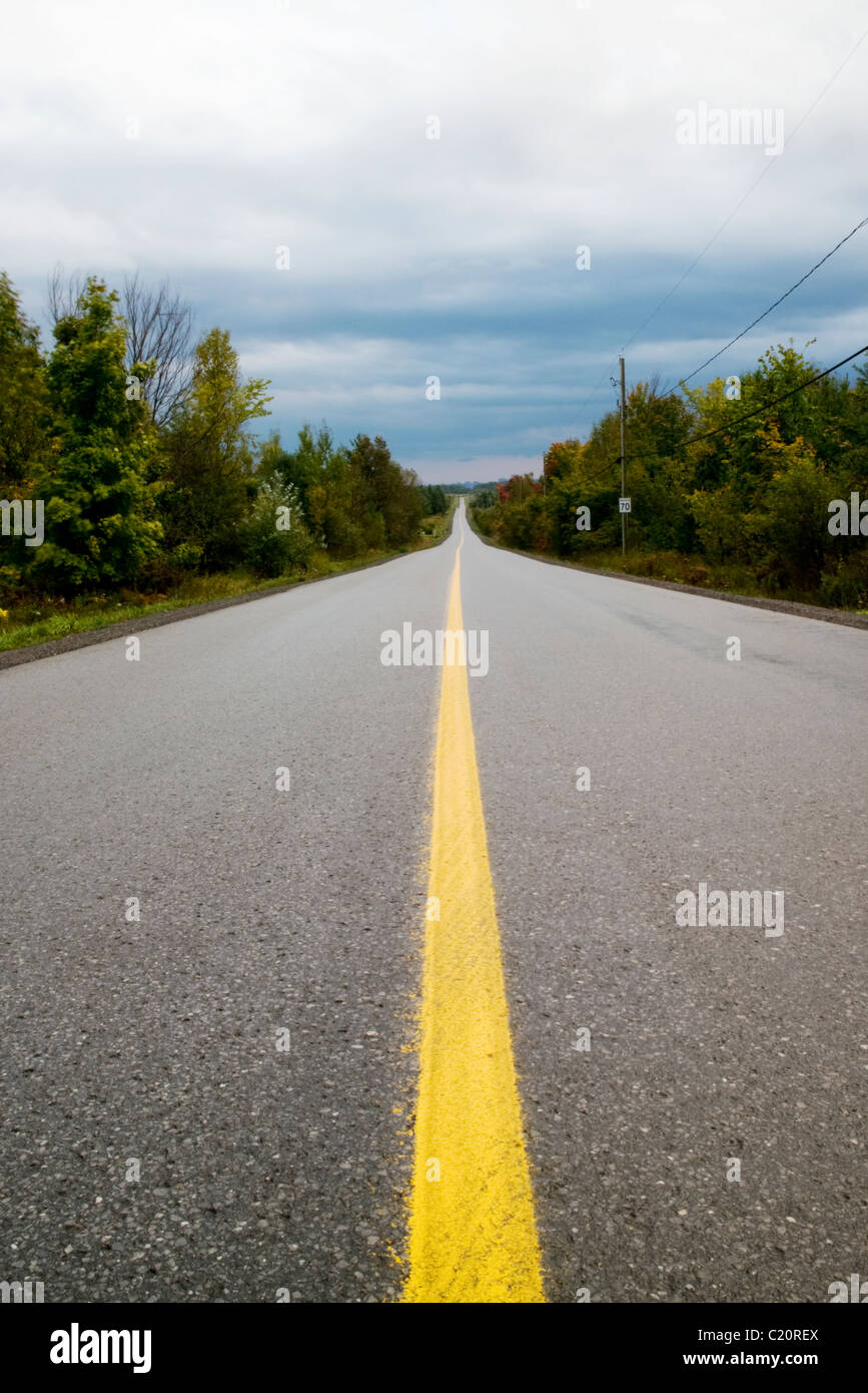 Rural paved road leading to city Stock Photo - Alamy
