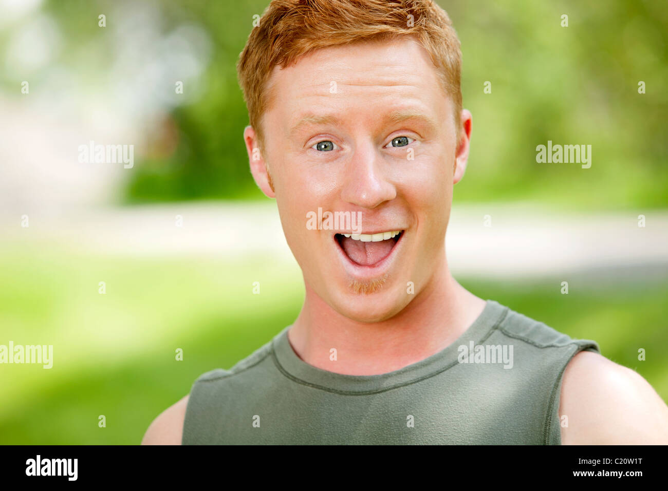 Excited man with mouth open against blur background Stock Photo - Alamy
