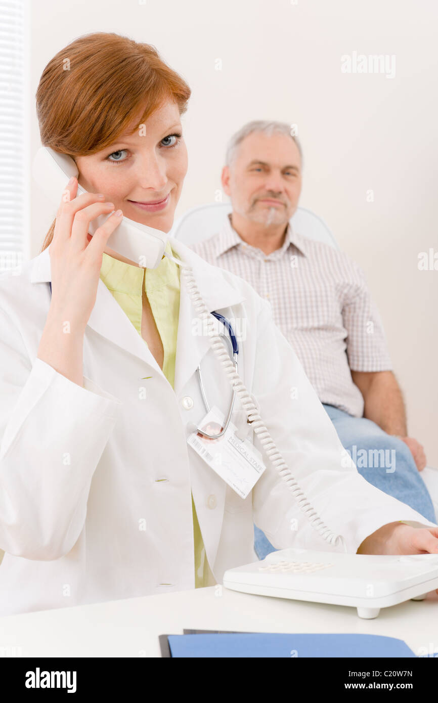 Doctor office - portrait female physician make phone call, senior ...