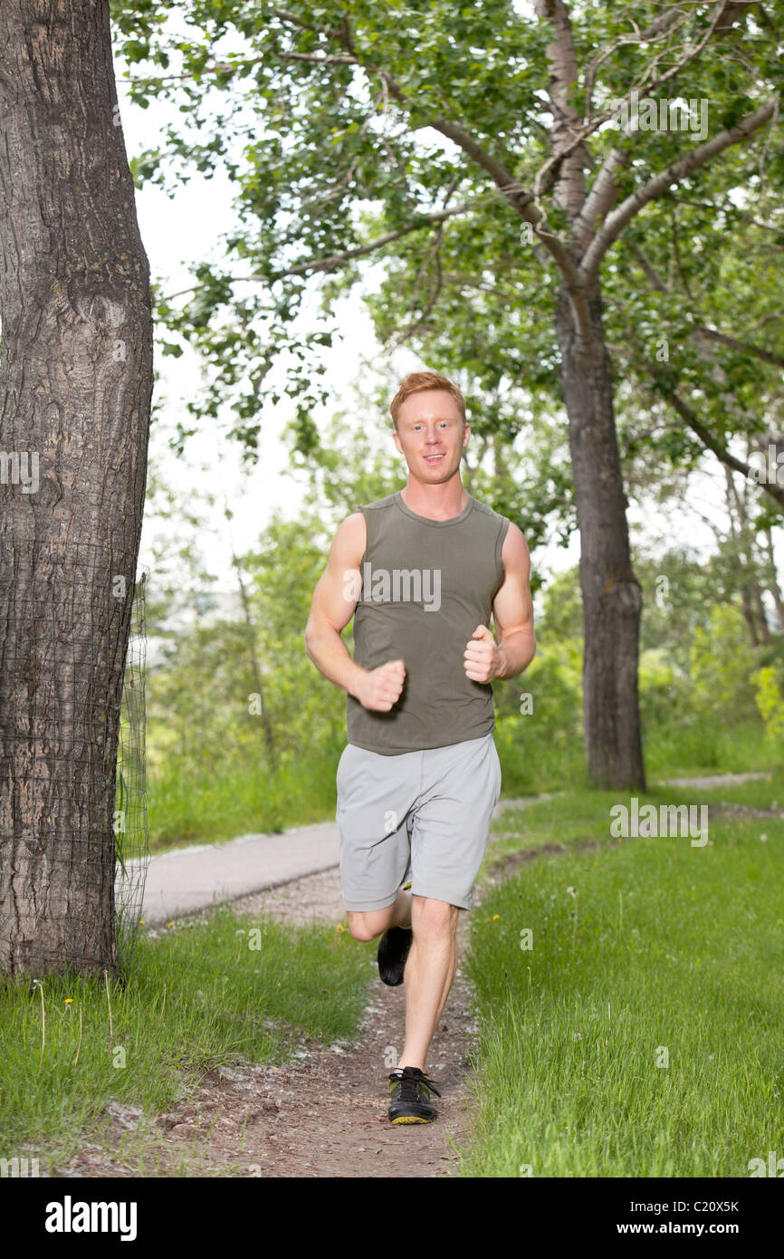 Portrait of a young man running in a park Stock Photo - Alamy