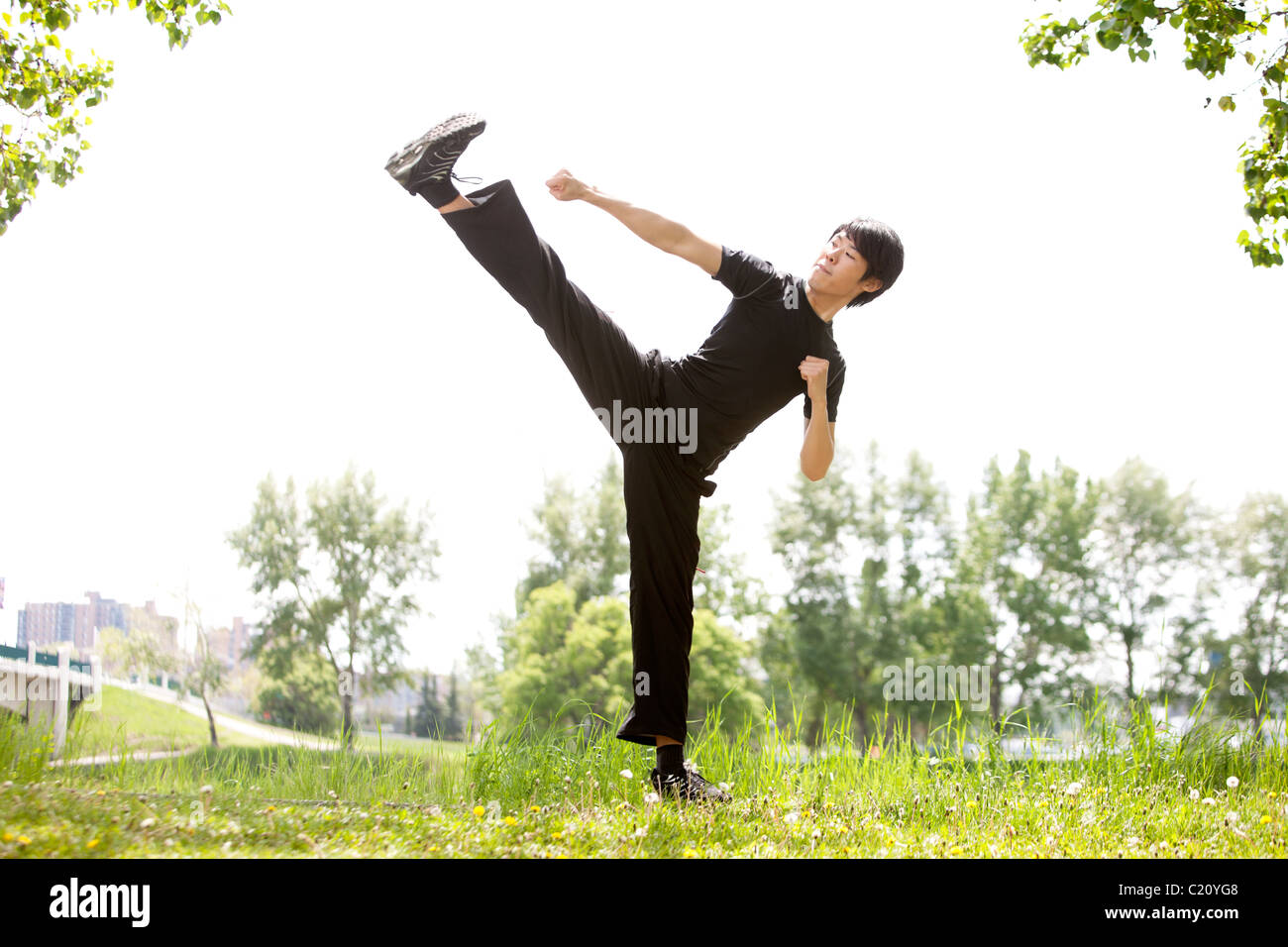Young Martial artist with his high side kick against blur background ...