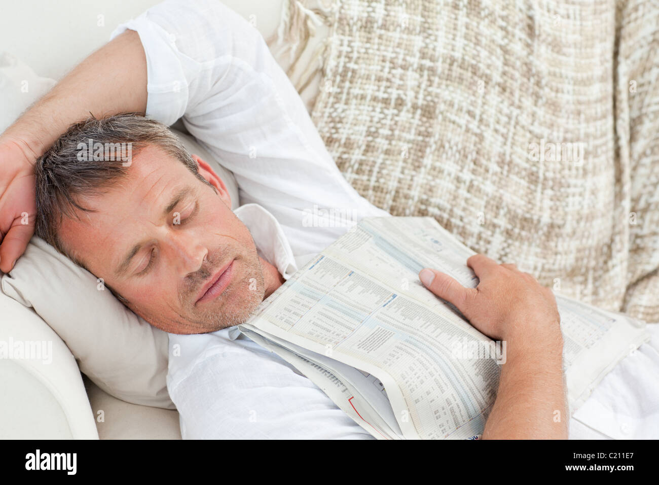 Exhausted man sleeping on the couch at home Stock Photo - Alamy
