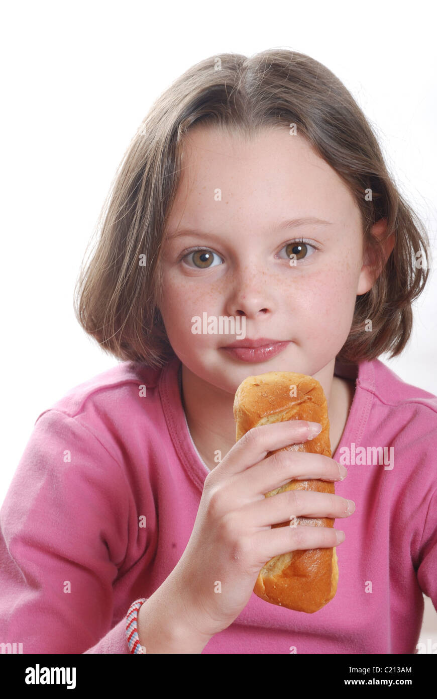A young girl eating a bun Stock Photo - Alamy