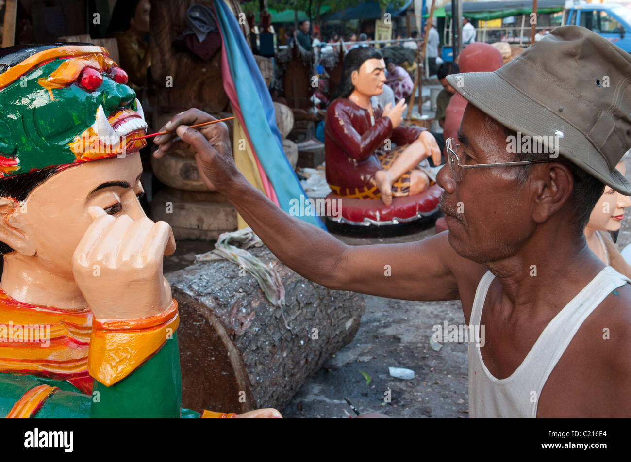 man painting a religious wooden statue. Shwedagon. yangon. Myanmar ...