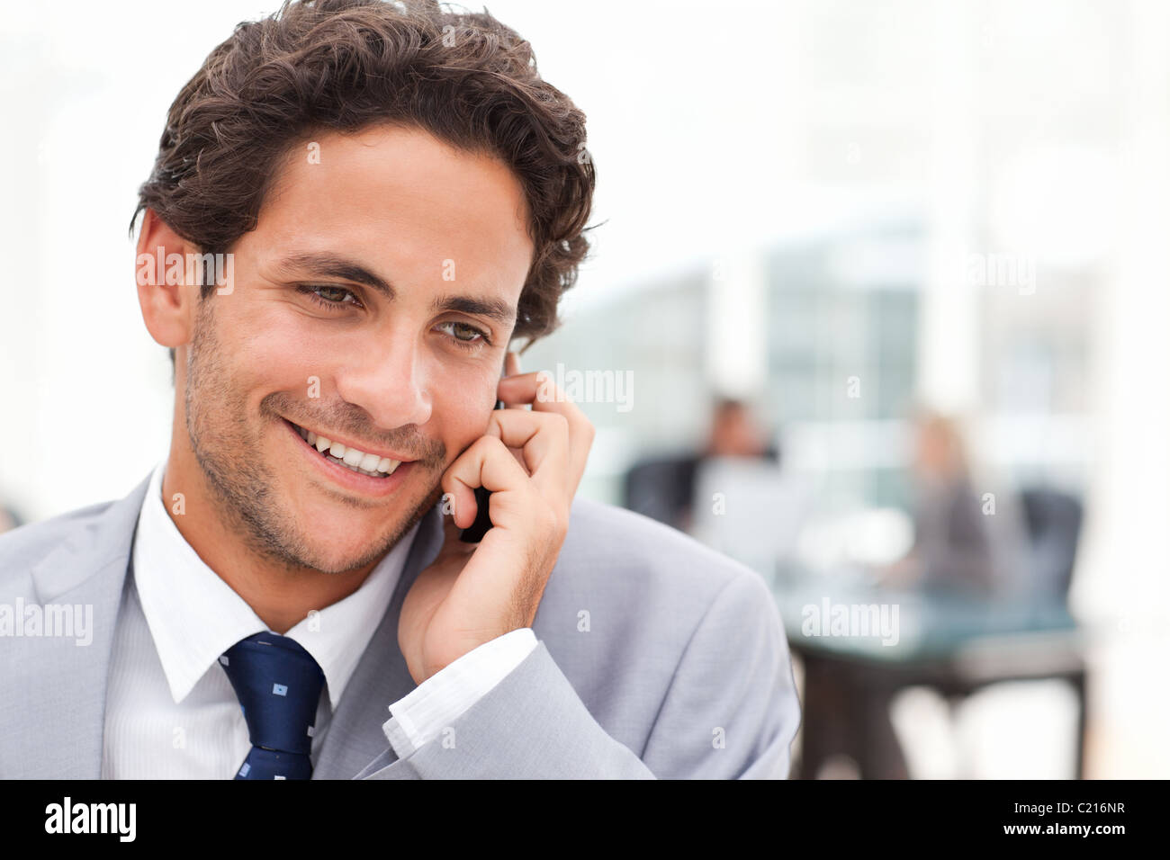 Charming businessman phoning in his office Stock Photo - Alamy