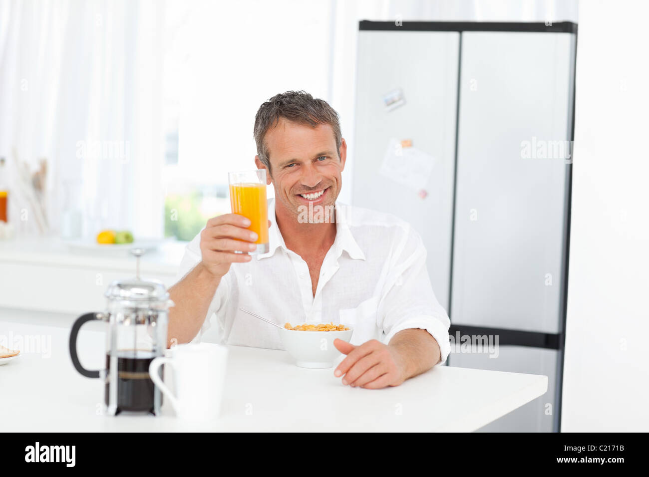 Handsome man having his breakfast in the kitchen Stock Photo - Alamy