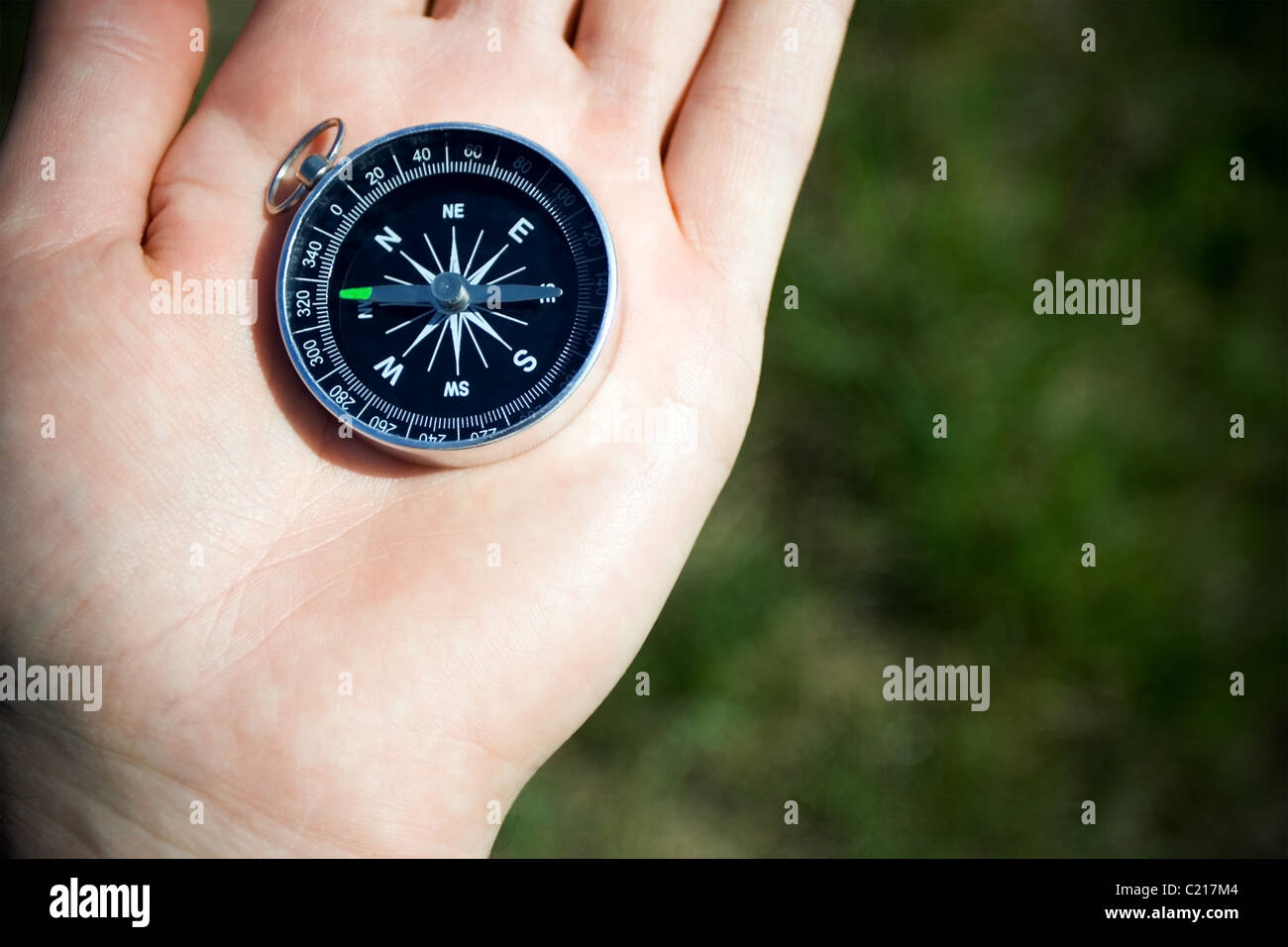 Classic compass on man's hand somewhere on trail during hiking. Green ...