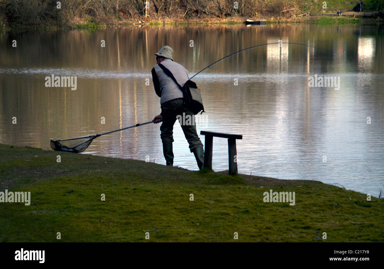 Reaching for a landing net Stock Photo - Alamy