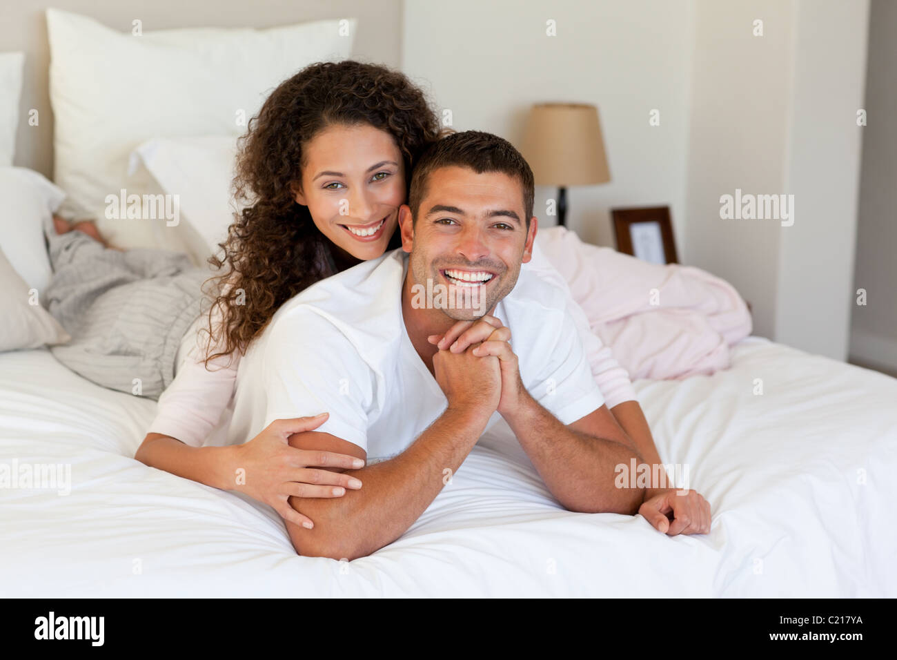 Pretty woman hugging her husband on their bed at home Stock Photo - Alamy