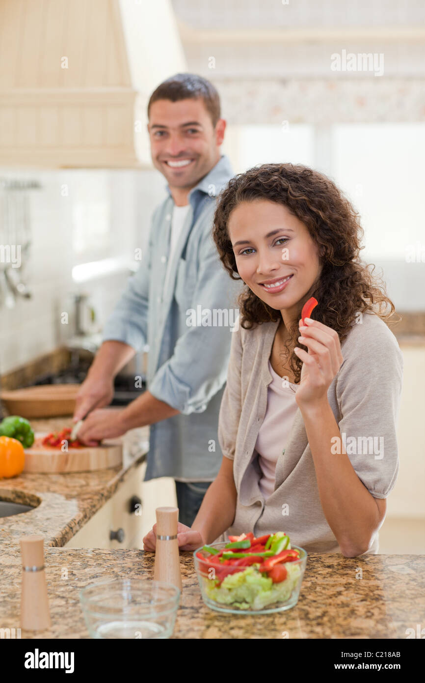 Woman eating while her husband is cooking Stock Photo - Alamy